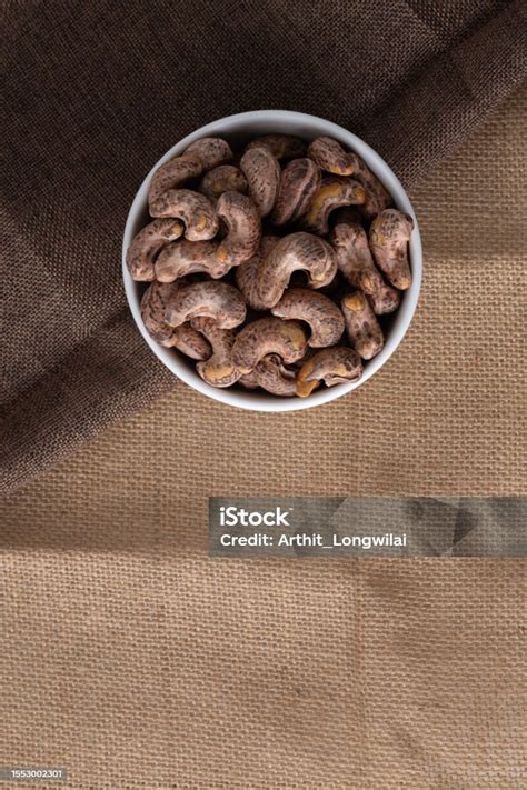 구운 캐슈넛과 반쪽을 테이블 위에 있는 나무 그릇에 담았다 매크로 스튜디오 샷 바구니에 담긴 수제 구운 소금에 절인 캐슈넛과 자루에 담긴 아침 식사 건강 식품 씨앗 스낵