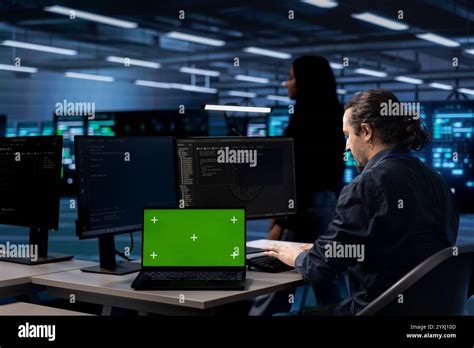 Admin In Data Center Uses Green Screen Laptop To Update Systems Protecting Servers From