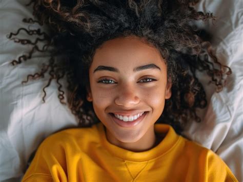 Premium Photo A Curly Haired Girl Lying In Bed Looking At The Camera