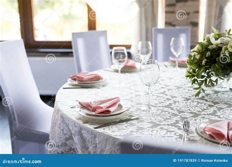 Праздничная сервировка стола с бокалами и свежими цветами Стоковое Изображение изображение