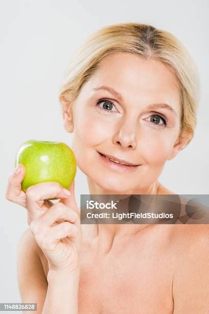 녹색 사과를 들고 아름 다운 성숙한 여 자가 회색 배경에 카메라를 보고 과일에 대한 스톡 사진 및 기타 이미지 과일 금발 머리 녹색 Istock