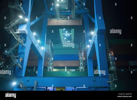 Operation Of Container Terminal At Night Unloading Container Ship At Night Mooring Cranes