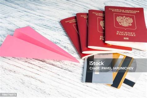 신용 카드가있는 빨간색 여권은 분홍색 종이 비행기 옆에 있는 나무 흰색 배경에 놓여 있습니다 개념에 대한 스톡 사진 및 기타 이미지 Istock