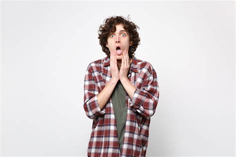 캐주얼에 충격 젊은 남자의 초상화 입을 열어 스튜디오에서 흰색 벽 배경에 고립 된 얼굴에 손을 넣어 사람들은 진심으로 감정 라이프 스타일 개념입니다 복사 공간을 모의 합니다
