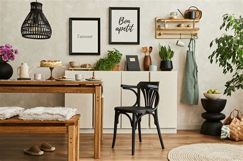 모의 포스터 프레임 베이지 색 컴모드 나무 테이블 의자 및 벤치 및 주방 액세서리가있는 아늑한 주방 인테리어 디자인의 세련된 구성 템플릿입니다 N 부엌에 대한 스톡 사진 및