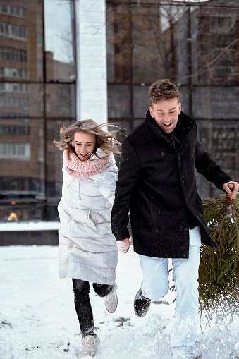 도시 거리에서 사랑에 빠진 아름 다운 행복한 젊은 커플 겨울에 입은 남자와 여자는 방금 크리스마스 트리를 사서 집에 가지고