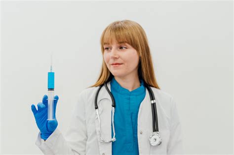 흰 가운을 입고 파란 장갑을 낀 여의사가 파란 액체가 담긴 주사기를 들고 있다 정밀성 안전 및 의료를 상징하는 임상 환경의 전문 의료 종사자 건강 진단에 대한 스톡 사진 및
