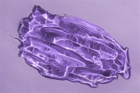 히알루론산 질감 작은 거품이 있는 화장품 근접 촬영 글리세린 또는 젤 스미어 스머지 스와치가 그림자가 있는 라일락 배경에 스머지 견본 스타일링 젤 로션 클렌저 투명 샴푸