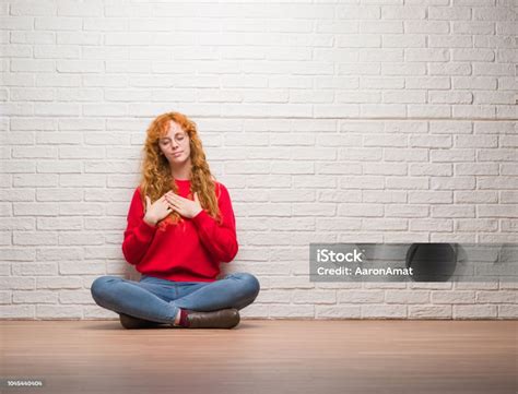 벽돌 벽으로 웃 고 앉아 젊은 빨강 머리 여자 얼굴에 닫힌된 눈와 감사와 함께 가슴에 손 건강 개념입니다 감사에 대한 스톡 사진 및 기타 이미지 Istock