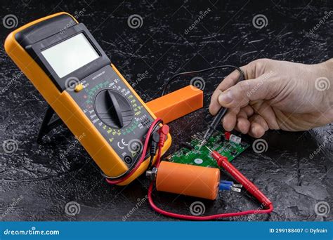 An Electrician Takes Readings From A Microcircuit Using A Multimeter Measuring Instruments