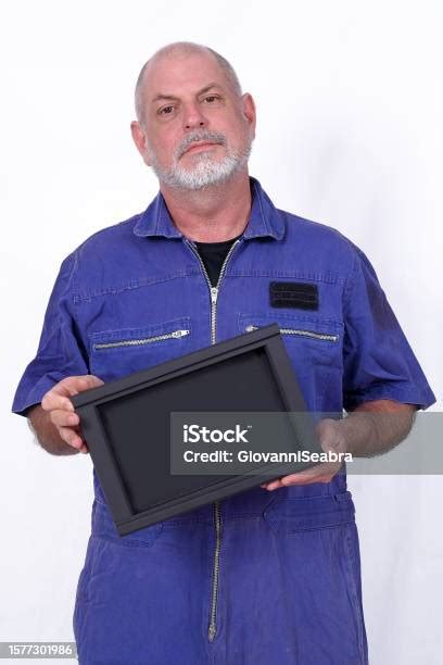 파란 작업복을 입은 하얀 수염 난 남자가 하얀 배경에 고립된 망치 도구를 들고 있다 50 54세에 대한 스톡 사진 및 기타 이미지 50 54세 50 59세 건설 산업