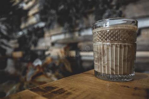 Ice Coffee In A Tall Glass With Cream Poured Over And Coffee Beans Cold Summer Drink On A Blue