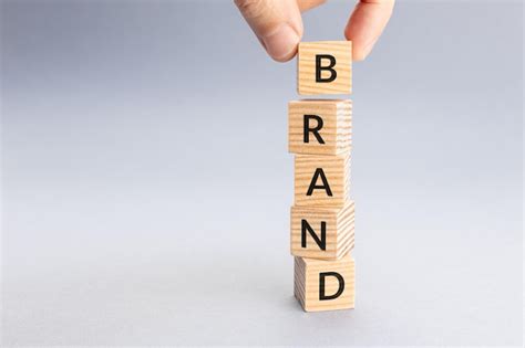 Premium Photo Hand Arranging Wooden Cubes To Spell Brand Word Copy Space
