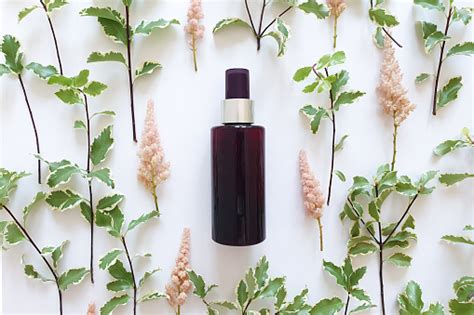 흰색 테이블에 브랜드가없는 갈색 화장품 스프레이 병 분홍색 꽃과 실크 리본 모형 스킨케어 미용 및 액상 항균 스프레이 컨셉 천연 유기농 스파 바디 미스트 0명에 대한 스톡