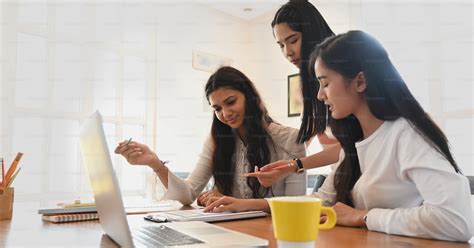 그래픽 디자이너 회의브레인스토밍은 커피 컵과 사무 기기로 둘러싸인 나무 작업 책상에 올려놓는 컴퓨터 노트북을 사용합니다 사진