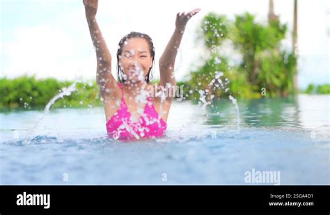 A Happy Smiling Young Woman Chest High In A Resort Swimming Pool Smiles As Stock Video Footage