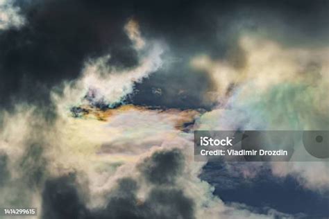 구름 속의 과냉각 된 물 방울에 대한 빛의 회절 맑은 화창한 날씨에 푸른 하늘에 대한 무지개 구름 누적 구름의 Irization 광학 현상 스펙트럼 색상 0명에 대한 스톡