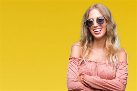 이상의 복고풍 선글라스를 입고 아름 다운 젊은 금발의 여 자가 행복 한 얼굴을 웃 고 넘어 무기는 카메라 보고 배경 고립