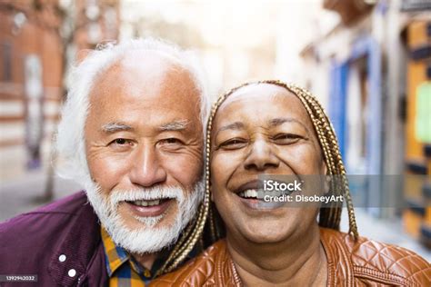 야외 카메라에 미소 짓는 다인종 노인 커플 아프리카 여성의 눈에 집중 노인 커플에 대한 스톡 사진 및 기타 이미지 노인 커플 휴가 2명 Istock