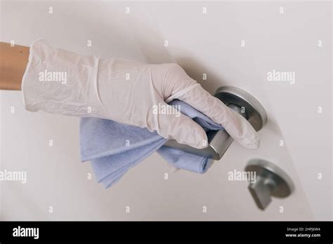 Cleaning Door Handle With Blue Wipe In White Gloves Sanitize Surfaces