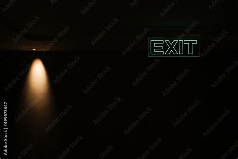 Green Exit Sign Isolated In Dark Black Room With Babe Yellow Spotlight Stock Photo Adobe Stock