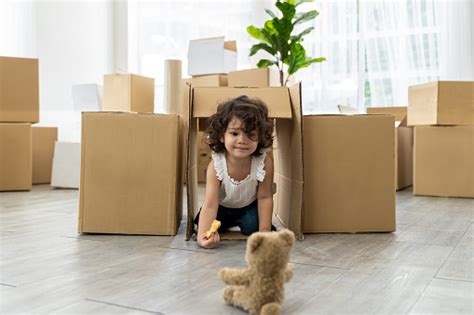 귀여운 유아 어린 소녀는 골판지 상자 안에 놀고 달콤한 디저트를 먹고 가족이 새로운 집으로 이사하기위한 골판지 상자를 포장합니다 18 23 개월에 대한 스톡 사진 및 기타