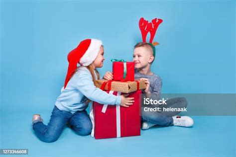 파란색 배경에 크리스마스 선물 상자와 산타 모자에 귀여운 어린 아이들 12월에 대한 스톡 사진 및 기타 이미지 12월 2명