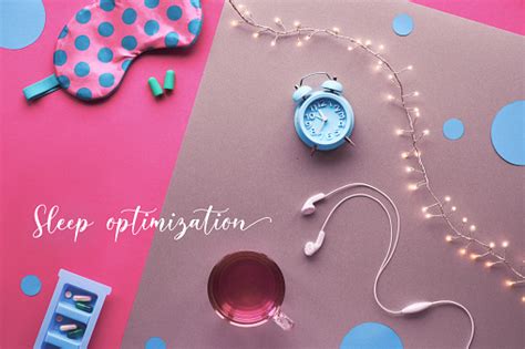 건강한 밤 수면 창조적 인 개념 수면 마스크 알람 시계 이어폰 귀마개 차 및 알약 밝은 화환으로 두 톤 핑크와 갈색 배경을 분할합니다 텍스트 수면 최적화 개념에 대한 스톡