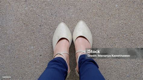 발과 다리는 위에서 볼 수 있습니다 거리 도로 배경에 파란색 바지와 골드 하이힐 신발을 입고 셀카 여자 맨 위 보기 가냘픈에