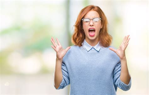 젊은 아름 다운 여자 미친과 미친 무기와 성공을 위한 겨울 스웨터를 입고 하는 고립 된 배경 위에 제기 하 고 흥분 비명 눈을