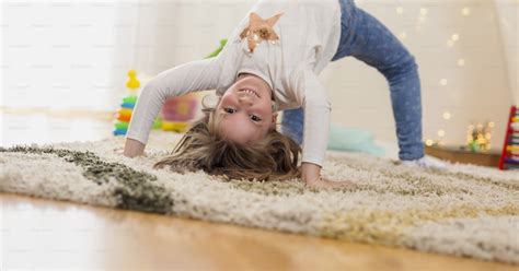 쾌활한 어린 소녀가 백벤드를 하고 놀이방에서 놀고 즐거운 시간을 보내고 있다 사진 Unsplash의 가정 생활 이미지