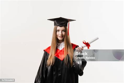 검은색 졸업 가운을 입고 흰색 배경에 모자를 쓴 석사 학위를 가진 대학원생 행복한 젊은 여성이 성공적으로 대학을 우등으로