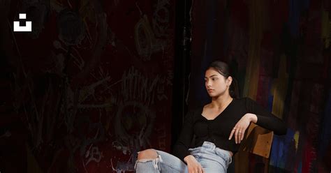 검은색 크루넥 티셔츠와 검은색과 빨간색에 앉아 있는 파란색 데님 청바지를 입은 남자 사진 Unsplash의 무료 의복 이미지