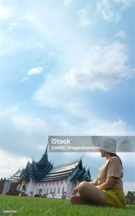 Portrait Of Asian Woman Sitting On Grass Garden At Buddhist Temple