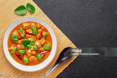 검은 슬레이트 배경에 흰색 접시에 타이어 파낭 치킨 카레 파나엥 카레는 닭고기 카피르 라임 잎 레드 카레 소스 채소를 곁들인 태국 요리입니다 태국 음식 복사 공간 0명에