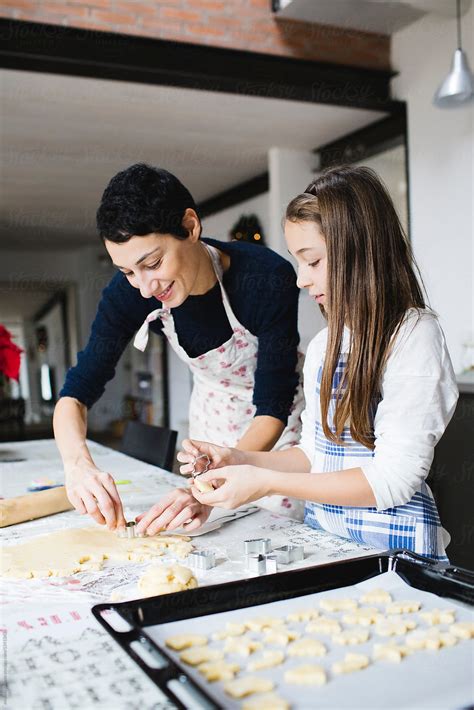 Mom Showing Her Daughter How To Prepare Cookies Del Colaborador De