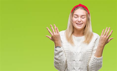 이상 겨울 스웨터를 입고 젊은 백인 여자 배경 축 제기 및 닫힌 눈 비명 흥분 하는 무기와 성공을 위해 미친 미친 하 고립