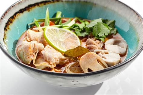 톰 얌 또는 톰 얌 닭고기와 뜨거운 신 타이어 수프 닭고기와 채소를 곁들인 태국 전통 수프 흰색 배경에 톰 얌 흰색 배경 위에 고립 된 수프 접시 건강한 생활방식에 대한