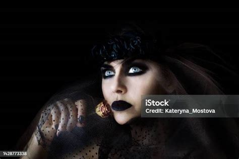 검은 입술을 가진 검은 머리 고딕 양식의 여성이 그녀의 손에 메이크업과 마른 장미를 만듭니다 마녀에 대한 스톡 사진 및 기타 이미지 Istock