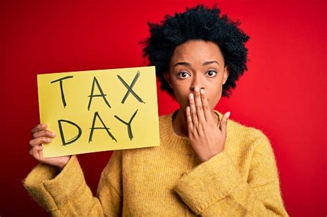 젊은 아프리카계 미국인 아프로 여자 와 곱슬 머리 들고 종이 와 세금 날 메시지 커버 입 손으로 충격 에 대한 수치심 두려움의 표현 침묵에 무서워 비밀 개념 가리기에 대한