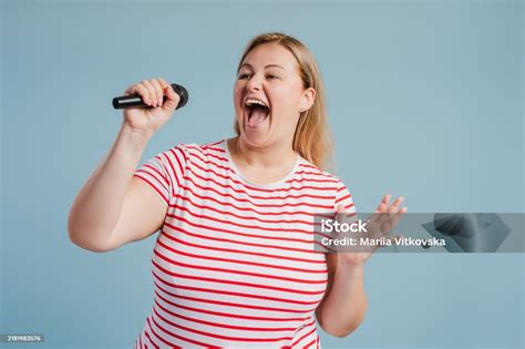 젊은 플러스 사이즈 백인 여성이 파란색에 고립 된 마이크와 함께 감정적으로 노래합니다 30 34세에 대한 스톡 사진 및 기타 이미지 30 34세 가수 개념 Istock