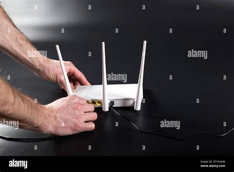 Hands Connecting White Wifi Router With Cable On Black Background Stock Photo Alamy