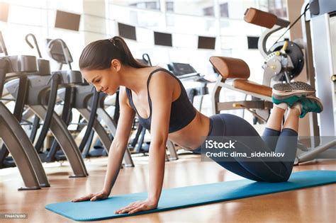 강하고 건강 합니다 스포티 한 젊은 여성이 하 고 운동 하는 동안 체육관에서 운동을 하는 측면 보기 스포츠에 대한 스톡 사진 및