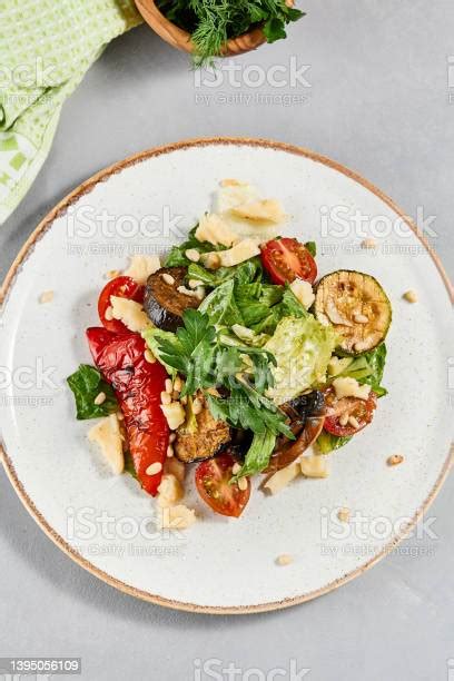 콘크리트 배경에 구운 야채 채소 및 치즈를 곁들인 샐러드 그릴에 파프리카 호박 가지 및 토마토와 함께 따뜻한 샐러드 채소 샐러드와 미적 구성 여름 메뉴 개념 샐러드에 대한