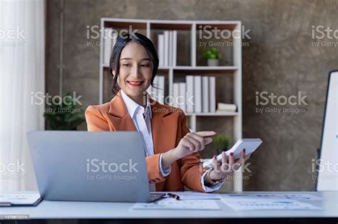 사무실 책상 세금 보고서 회계 통계 및 분석 연구 개념에서 수학 금융을 수행하기 위해 계산기와 노트북을 사용하는 아시아 비즈니스