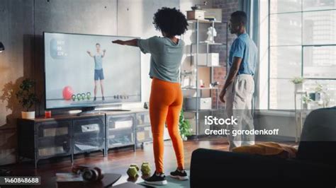 흑인 강한 커플은 집에서 함께 훈련하고 Tv에서 튜토리얼을 시청합니다 아름다운 남자 친구와 운동복을 입은 여자 친구는 피트니스 운동을합니다 성공적인 신체 훈련 개념 홈