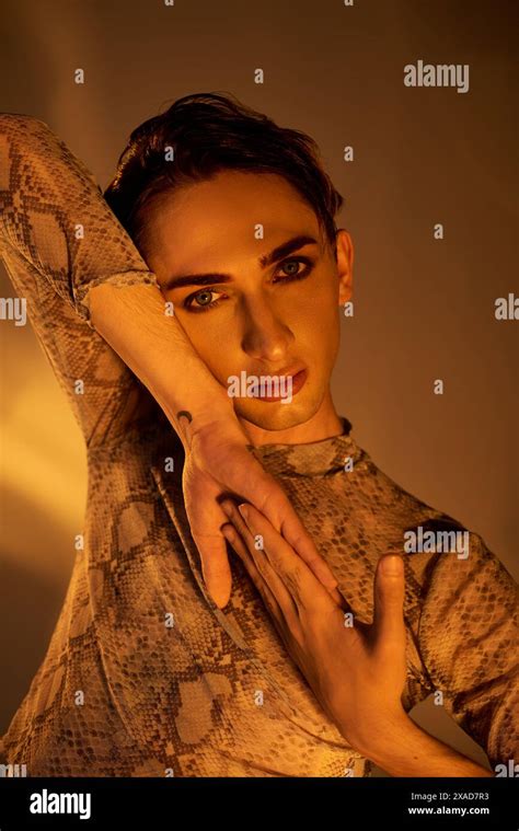 A Young Queer Person Confidently Poses In A Python Skin Dress