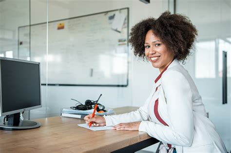 사무실에서 그녀의 메모장에 쓰고 카메라를 보고 아프리카계 미국인 사업가 30 39세에 대한 스톡 사진 및 기타 이미지 30 39세 곱슬 머리 긍정적인 감정 표현