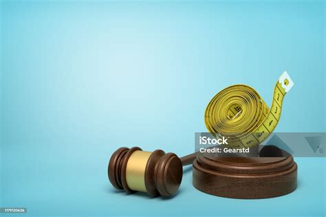 노란색 측정 테이프의 롤의 3d 렌더링은 밝은 파란색 배경 옆에 망치와 소리 블록 위의 공기에 떠있습니다 3차원 형태에 대한