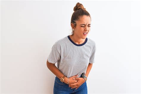 젊은 빨간 머리 현대 여자 는 소화 불량 아픈 질병 이 좋지 않은 느낌 때문에 위장에 손으로 고립 된 배경 위에 롤빵을 입고 아쉬 컨셉 건강관리와 의술에 대한 스톡 사진 및